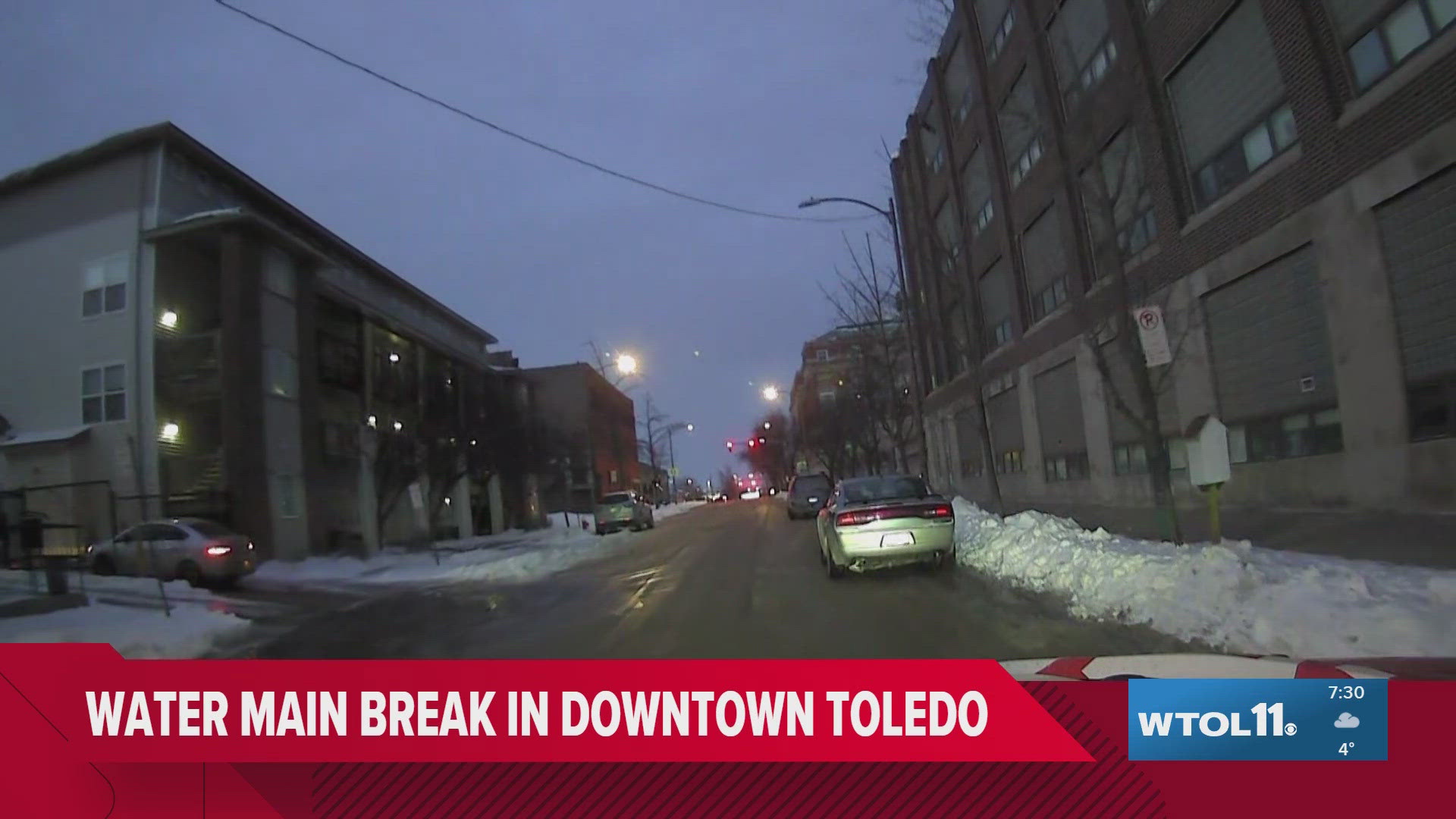 Water pouring onto street from apartment building in downtown Toledo ...